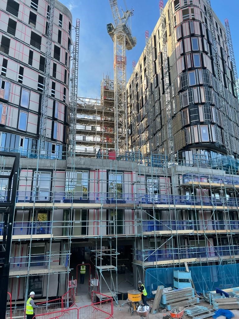 is a detailed white brick podium build with two 13 floor copper towers ...